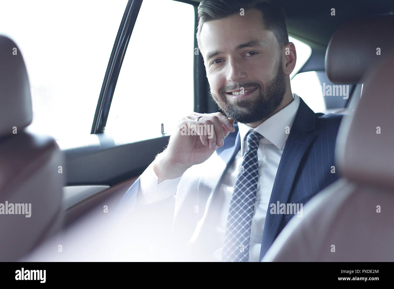 Smiling business man sitting in the back seat of a car Stock Photo - Alamy