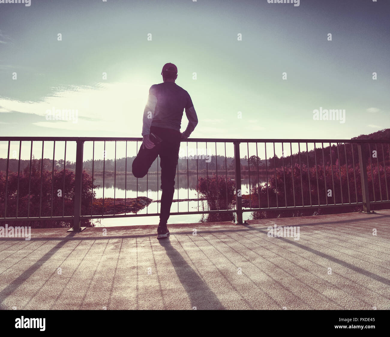 Workout runner. Man do stretching, taking a break from run outside in ...