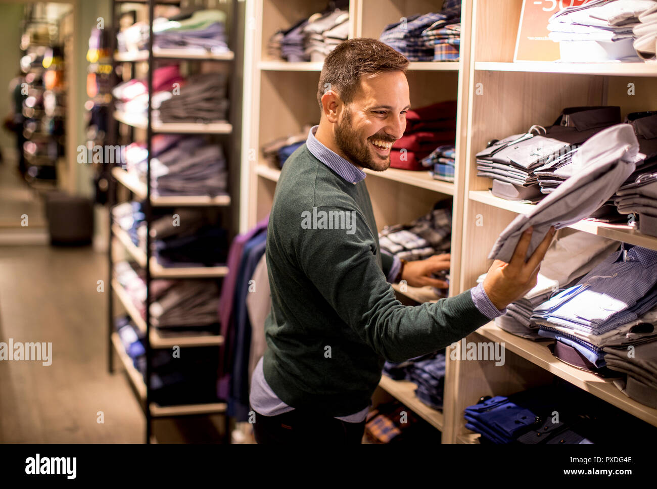 Handsome young man buying clothes in the store Stock Photo - Alamy