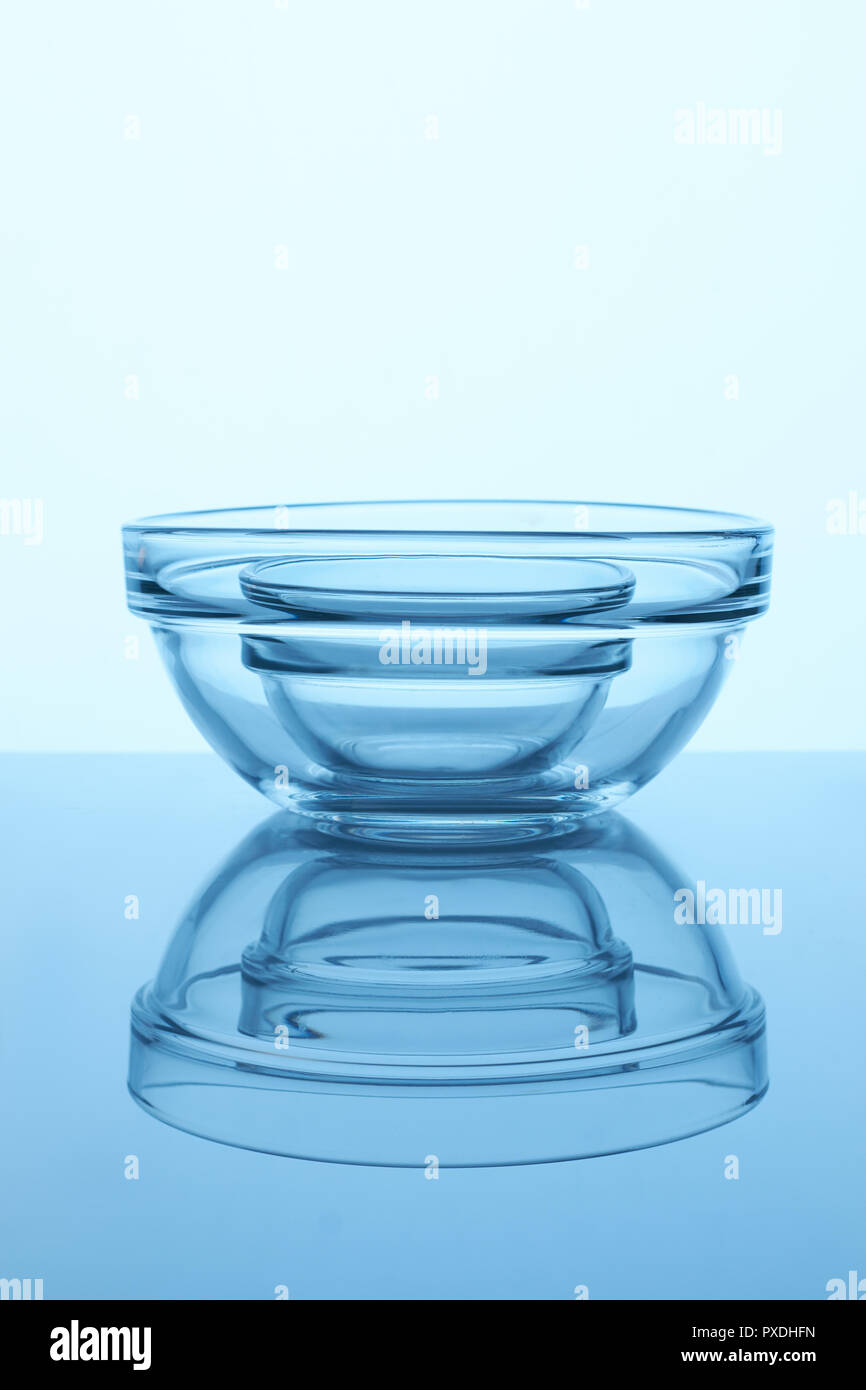 Transparent bowls on reflective surface Stock Photo - Alamy