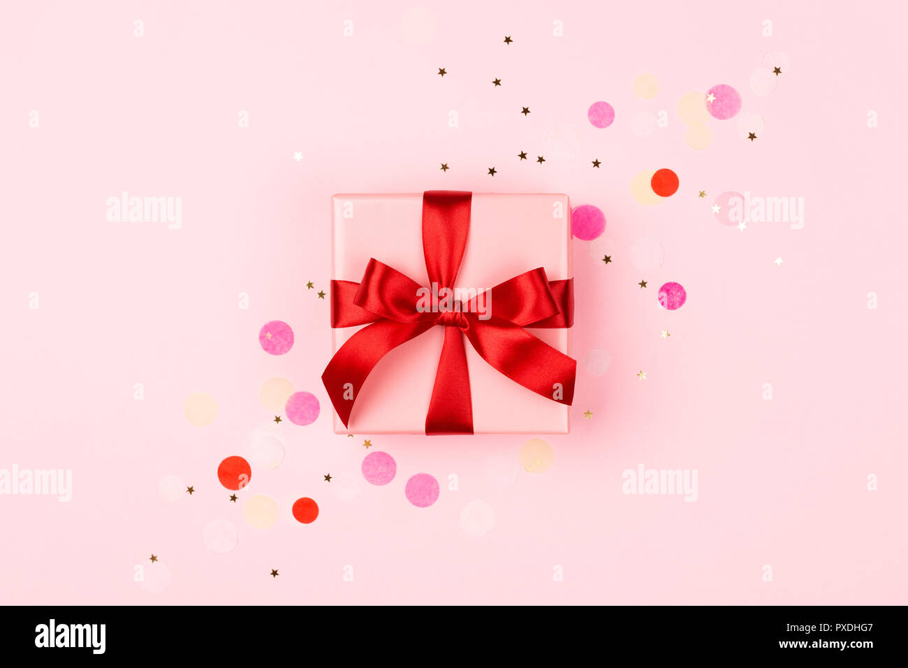 Pink gift box with red bow on pink background with sparkles. Holiday ...