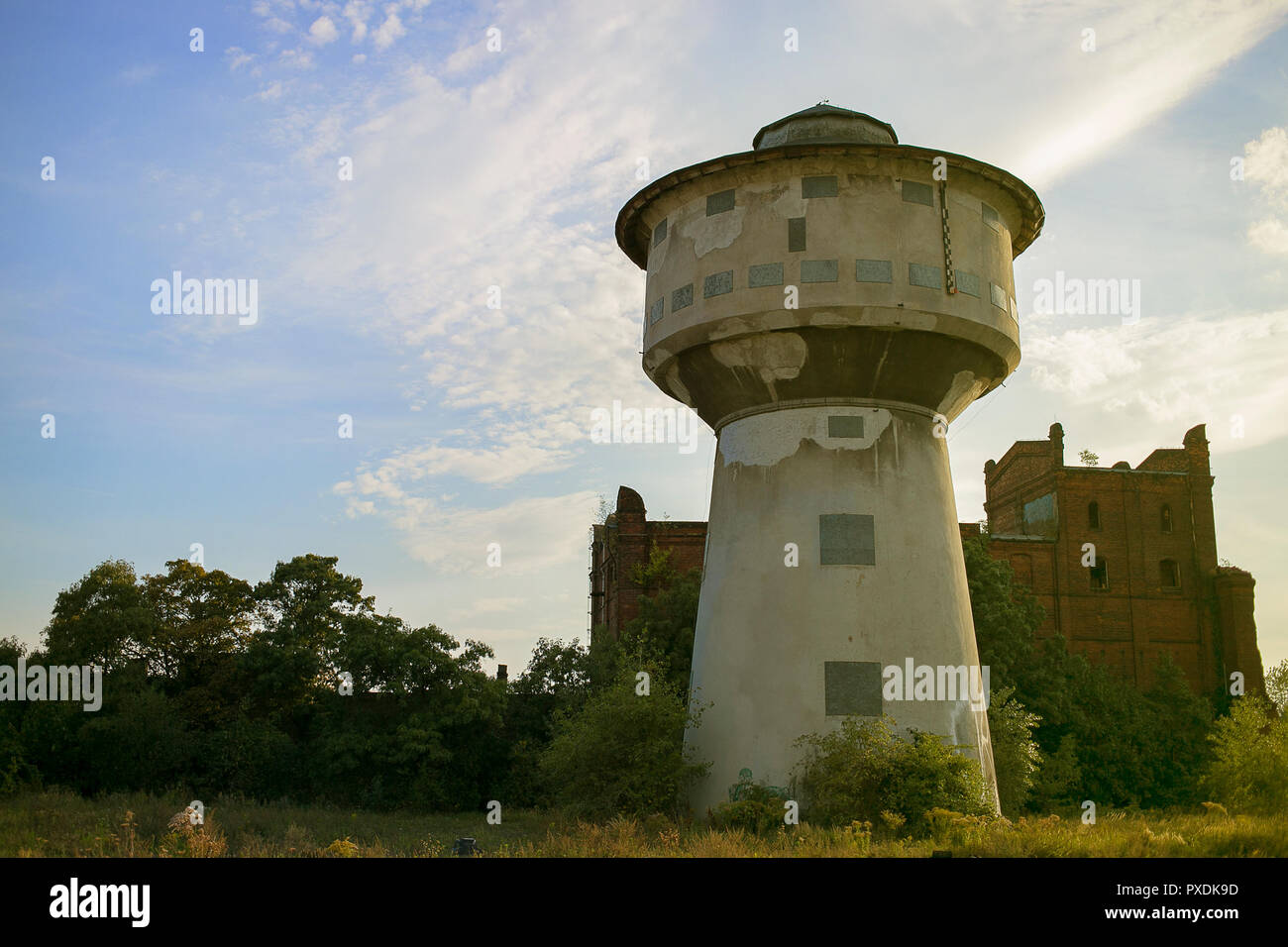 An old abandoned water tower by ruined factory in Poland Stock Photo ...