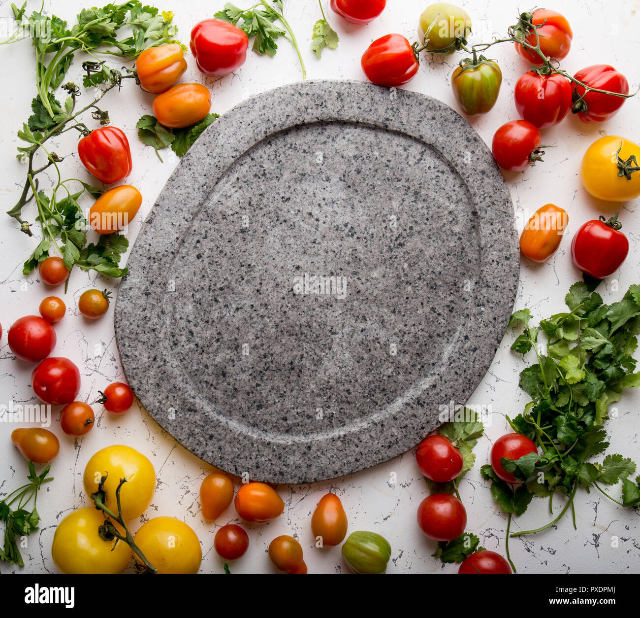 Gray empty stone plate and fresh cooking ingredients - green. red ...