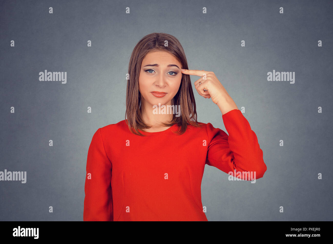 Angry woman gesturing with finger against temple are you crazy Stock ...