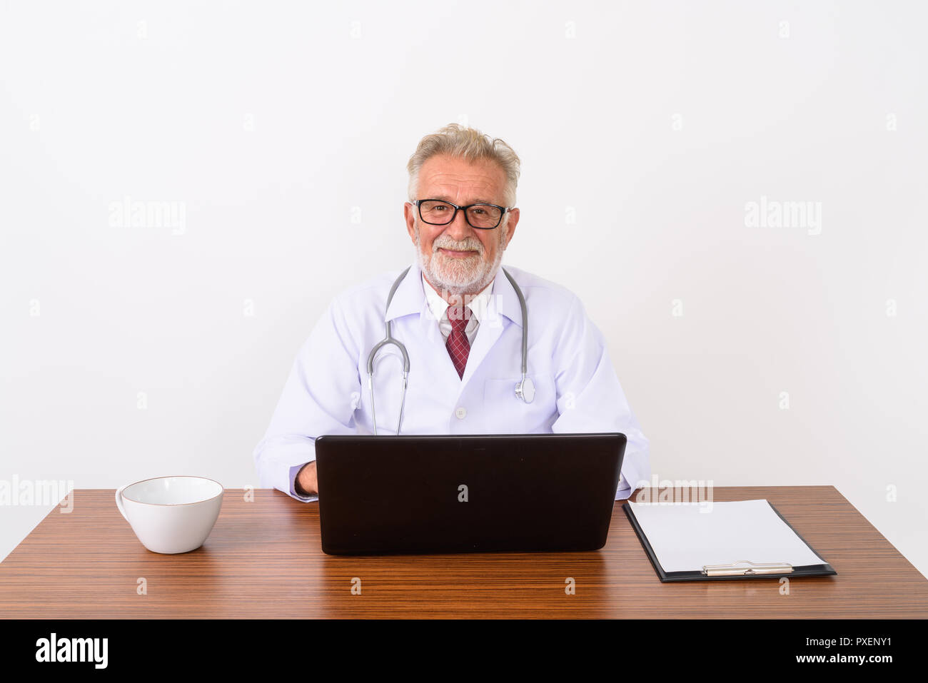 Studio shot of handsome senior bearded man doctor with laptop on Stock ...