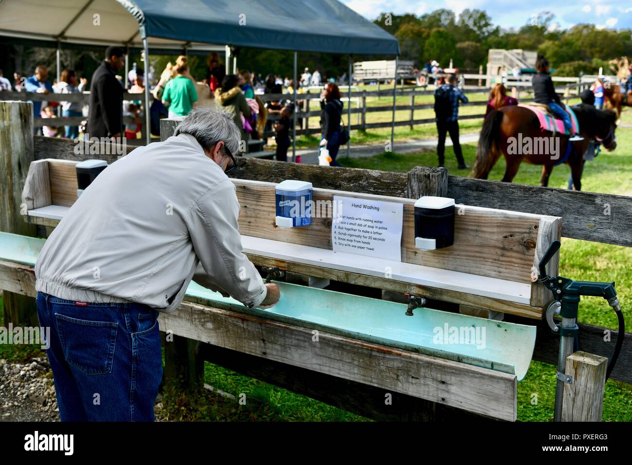 Man washing hands at a petting zoo wash station Stock Photo - Alamy