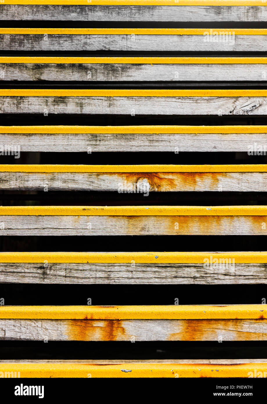 Weathered and rusty timber staircase with yellow metal inserts that ...