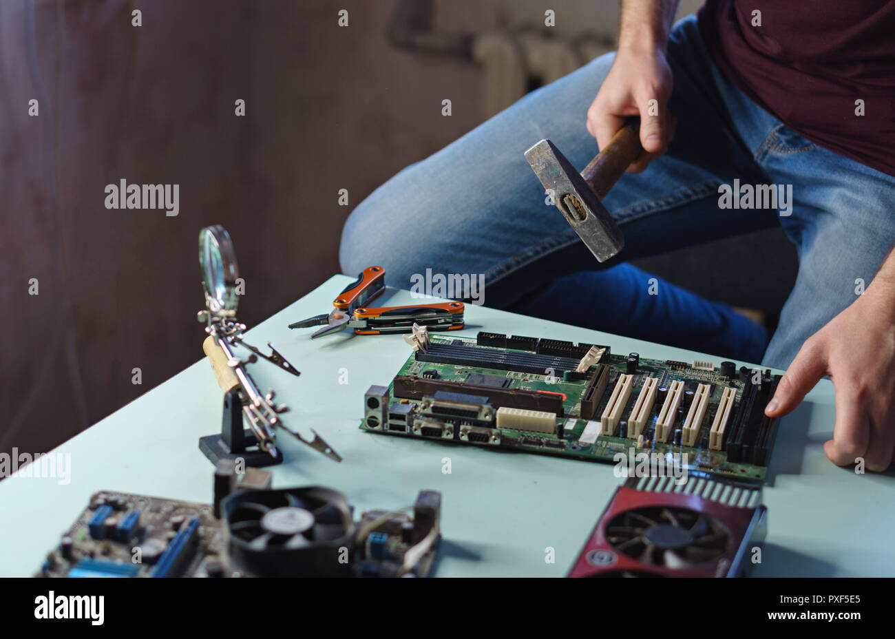 Repair motherboard. Man hammer dismantles the motherboard. Working ...