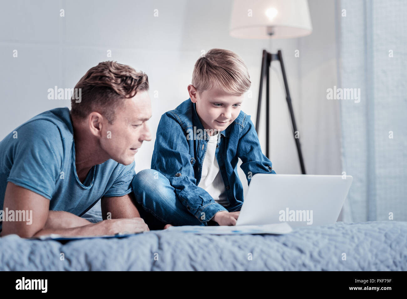 Concentrated interested boy sitting and using the laptop Stock Photo ...
