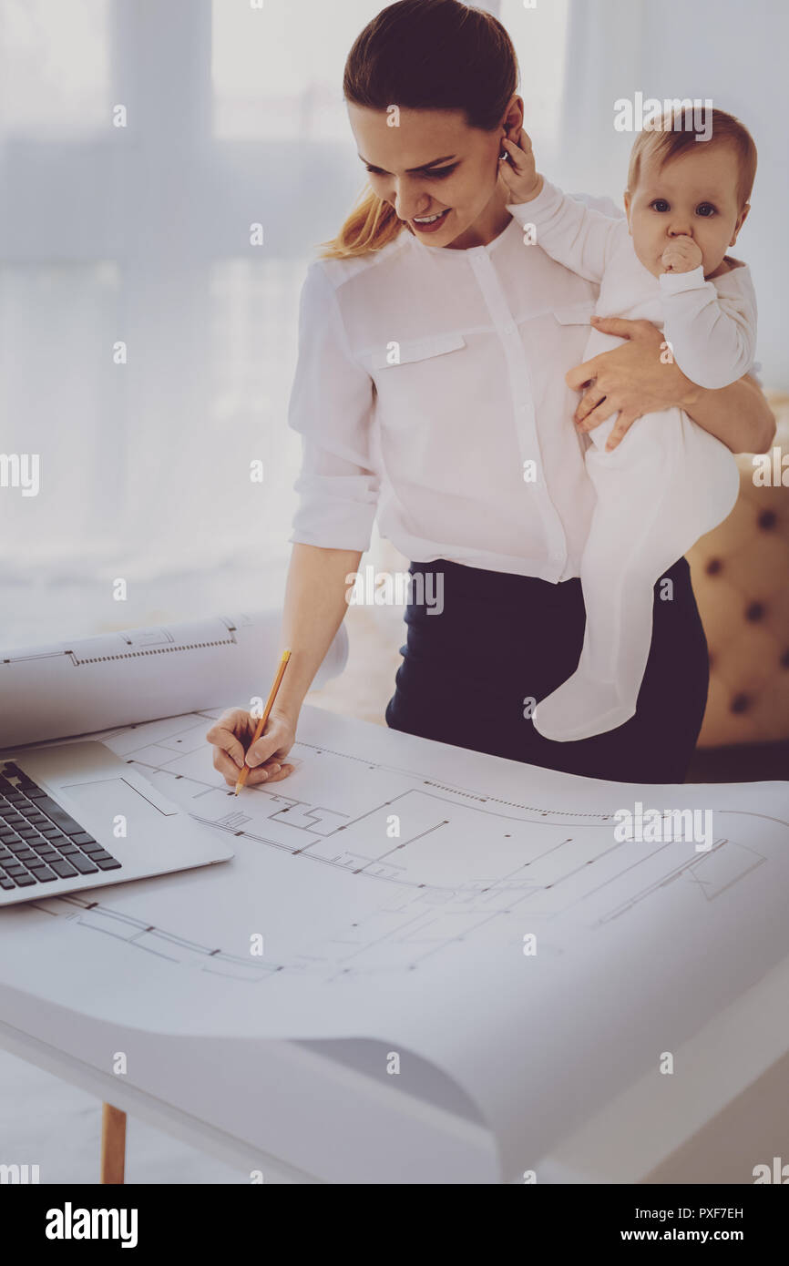 Working successful mother engineering serious project while holding ...
