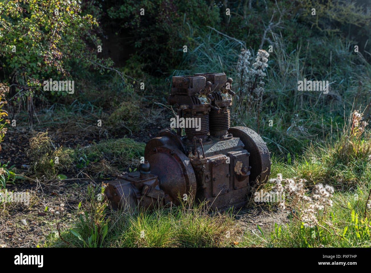 A discarded and rusty old marine engine on the shoreline of Chichester ...
