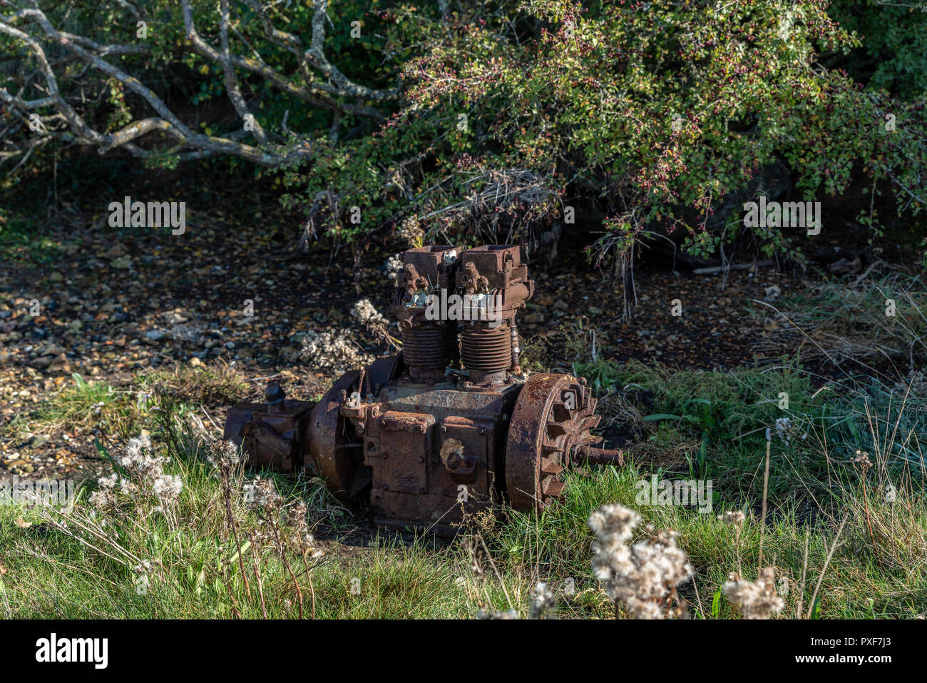A discarded and rusty old marine engine on the shoreline of Chichester ...