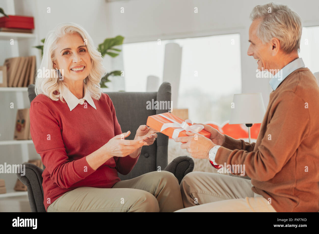 Cheerful elderly man making a present for his wife Stock Photo - Alamy