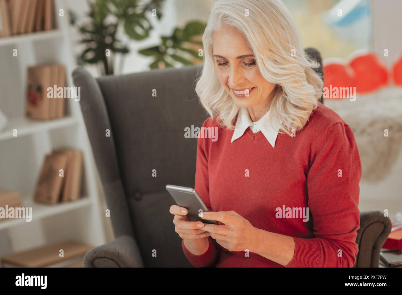 Cheerful senior lady browsing funny sites on smartphone Stock Photo - Alamy