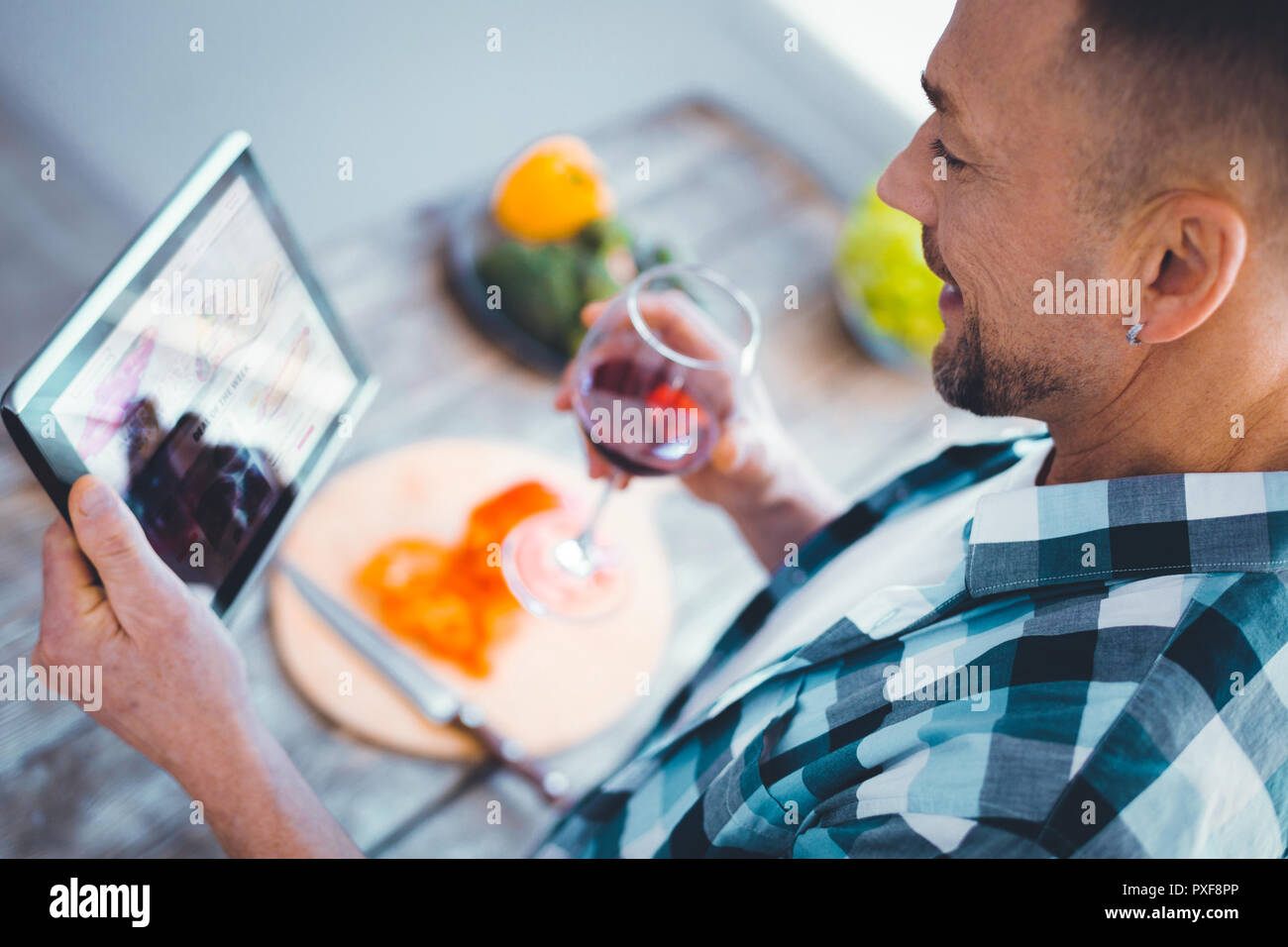 Joyful positive man looking at the tablet screen Stock Photo - Alamy
