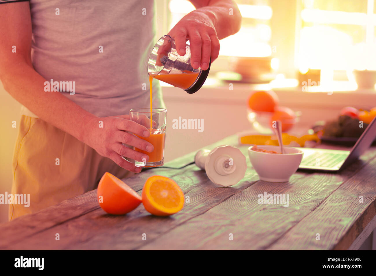 Serious joyful man drinking fresh juice in the kitchen Stock Photo - Alamy