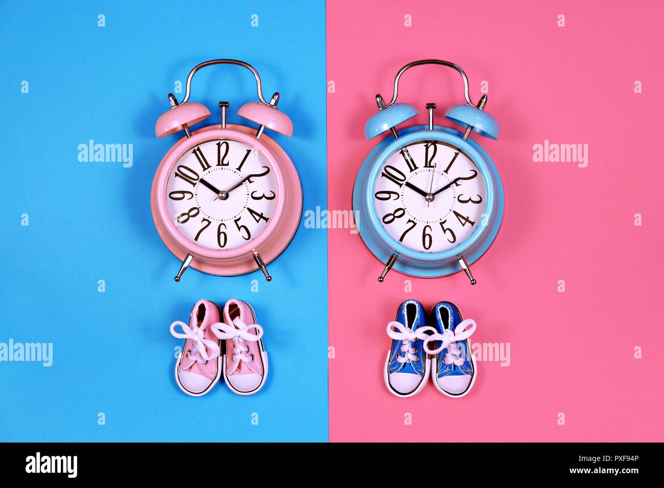 Two alarm clocks on blue pink background, twins concept Stock Photo - Alamy