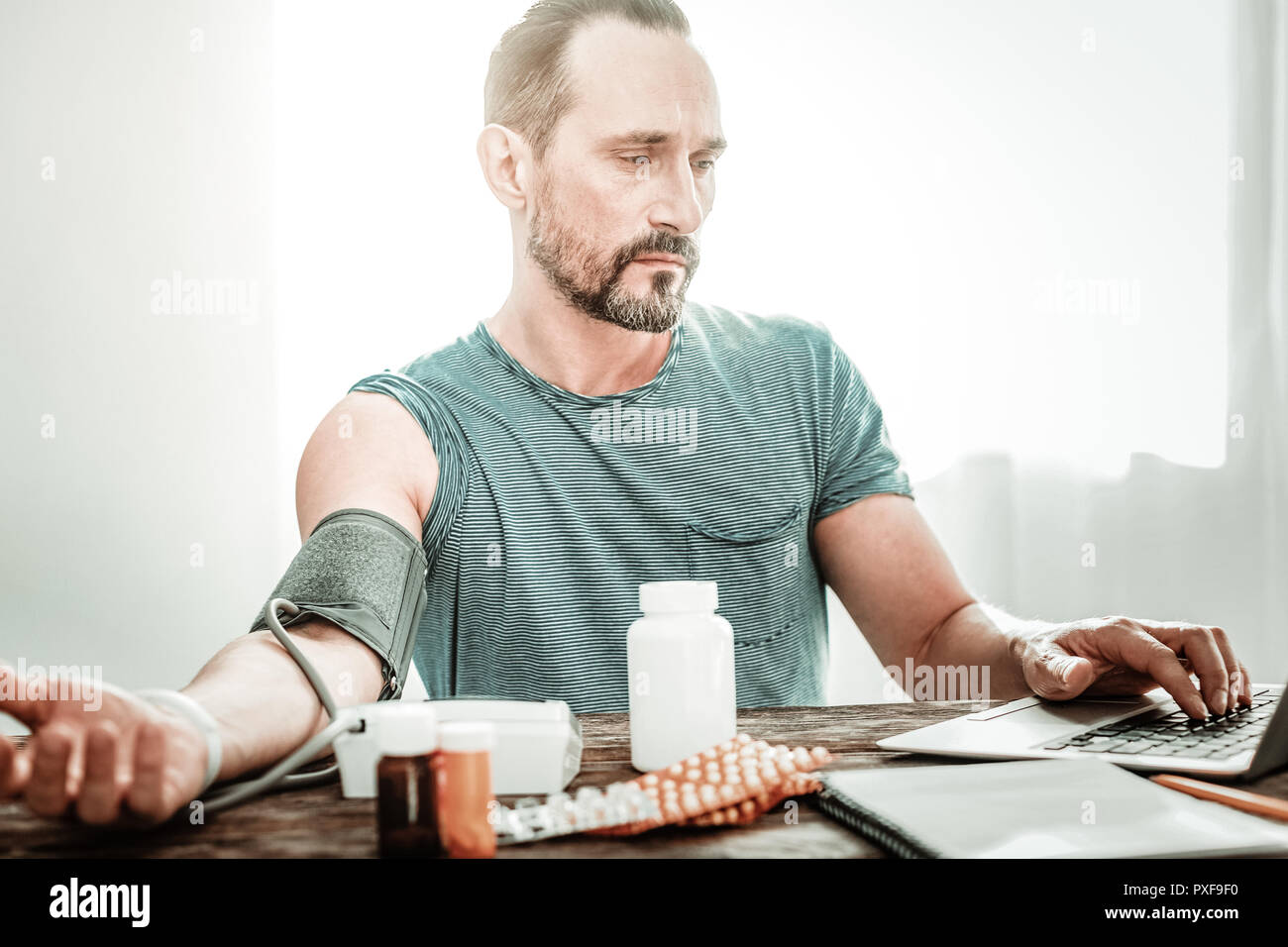 Cheerless sad man sitting in front of the laptop Stock Photo - Alamy
