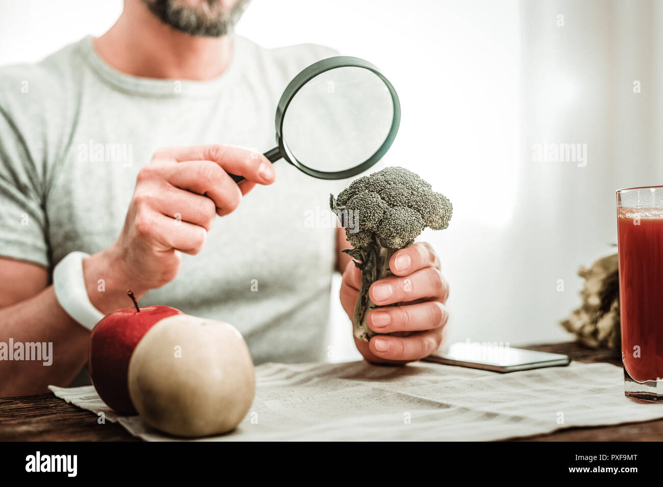 Nice pleasant adult man using magnifying glass Stock Photo - Alamy