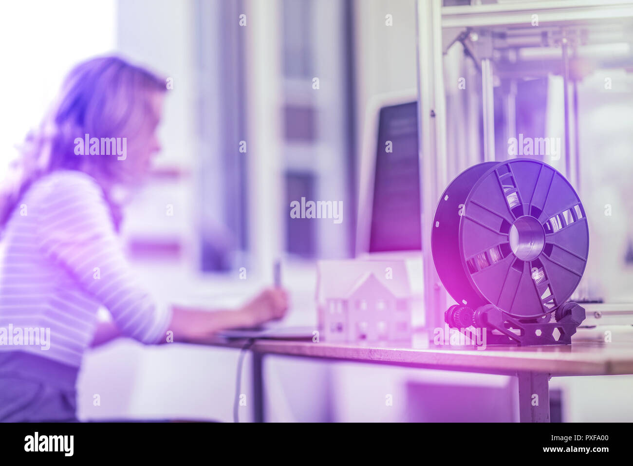 Blonde-haired female software engineer sitting at the table in front of ...
