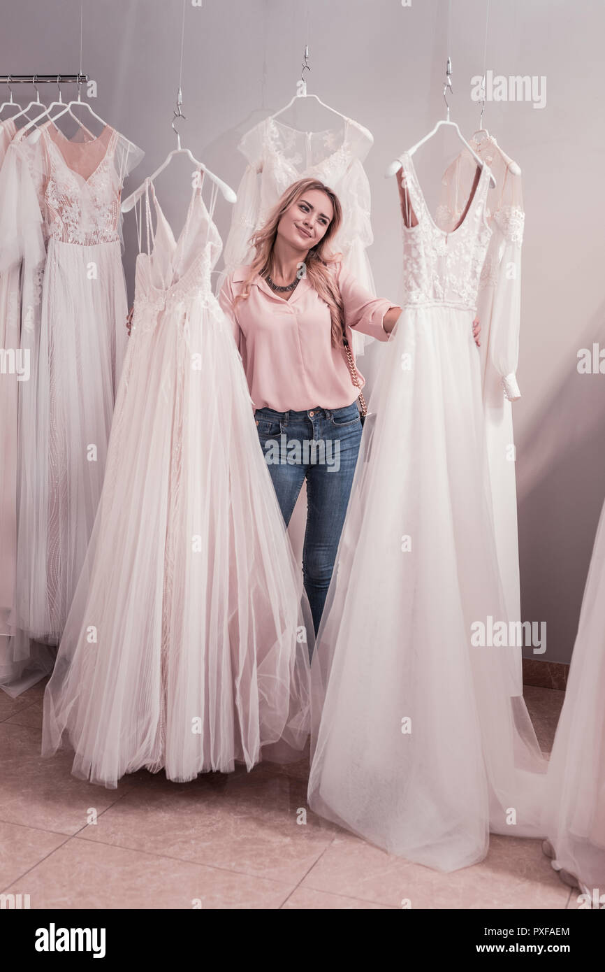 Joyful young woman standing near wedding dresses Stock Photo - Alamy Joyful young woman standing near wedding dresses Stock Photo - Alamy