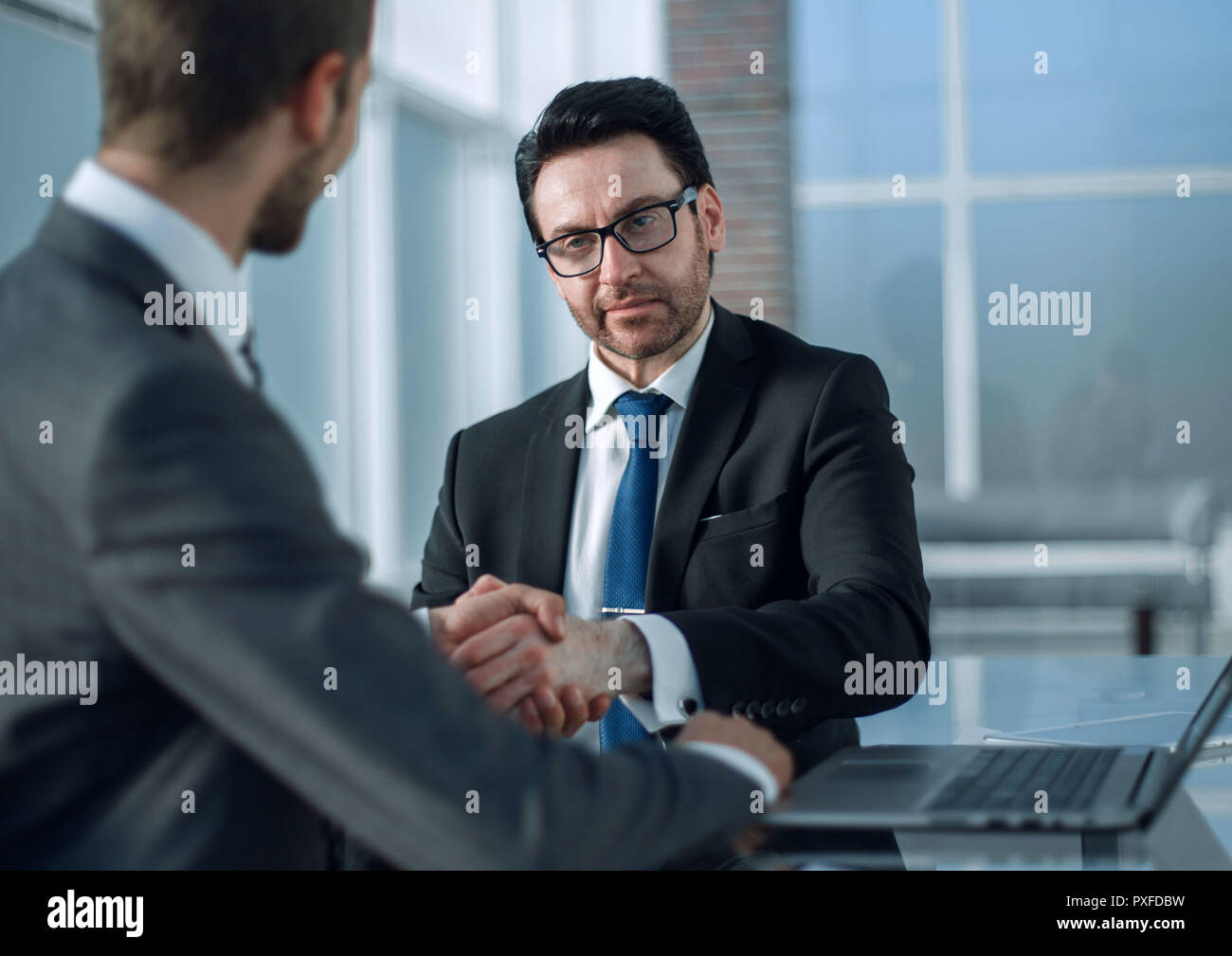 Men shaking hands at a conference table hi-res stock photography and ...