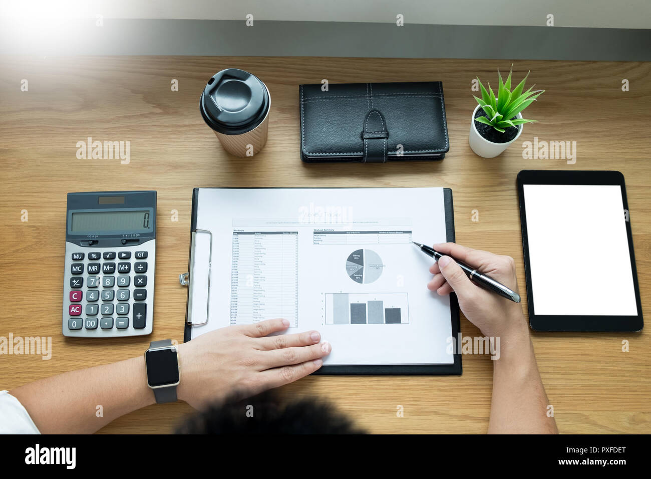 businessman going through some paperwork and signing a document at desk ...