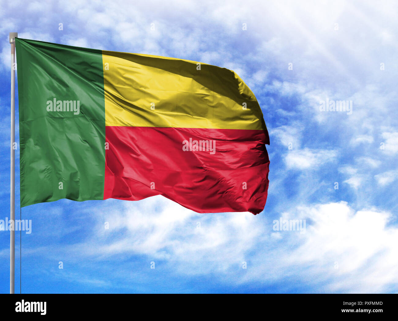 National flag of Benin on a flagpole in front of blue sky Stock Photo ...