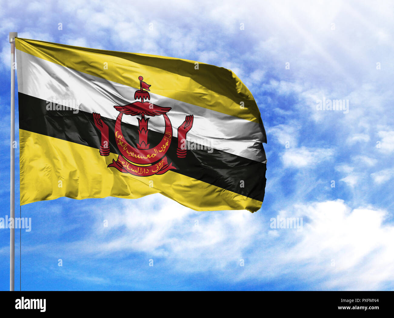 National flag of Brunei on a flagpole in front of blue sky Stock Photo ...