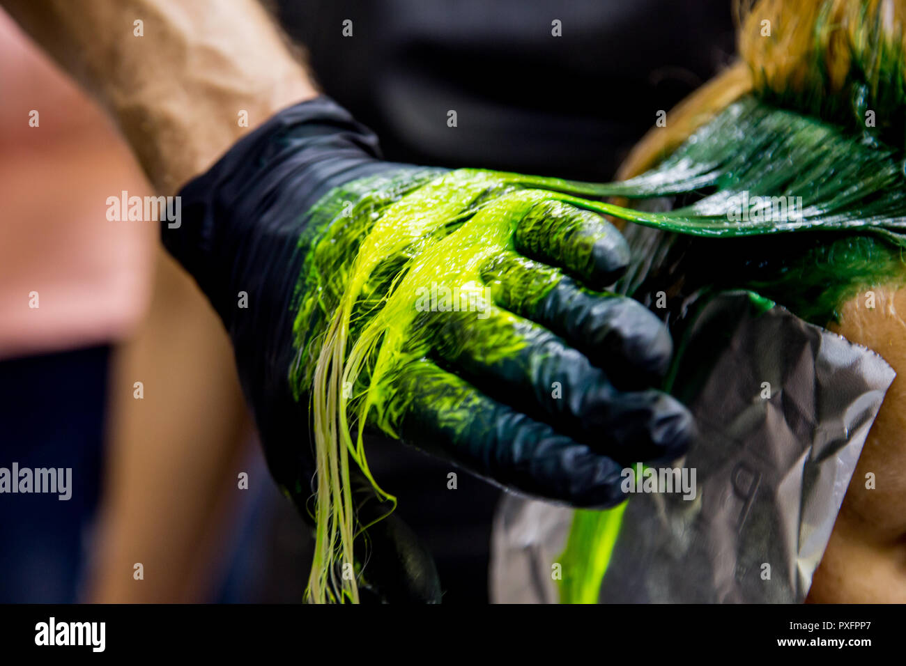 Professional hairdresser dyeing hair. Multicolor Fluorescent staining ...