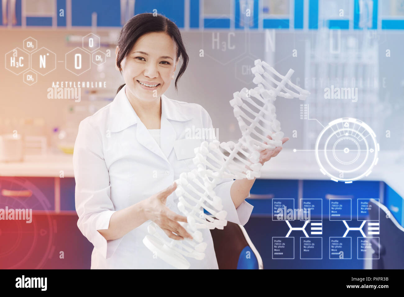 Positive biologist smiling and holding a big DNA model Stock Photo - Alamy