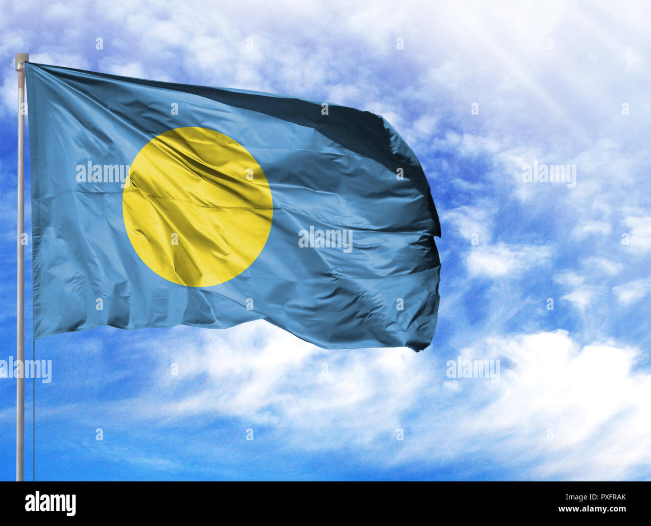 National flag of Palau on a flagpole in front of blue sky Stock Photo ...