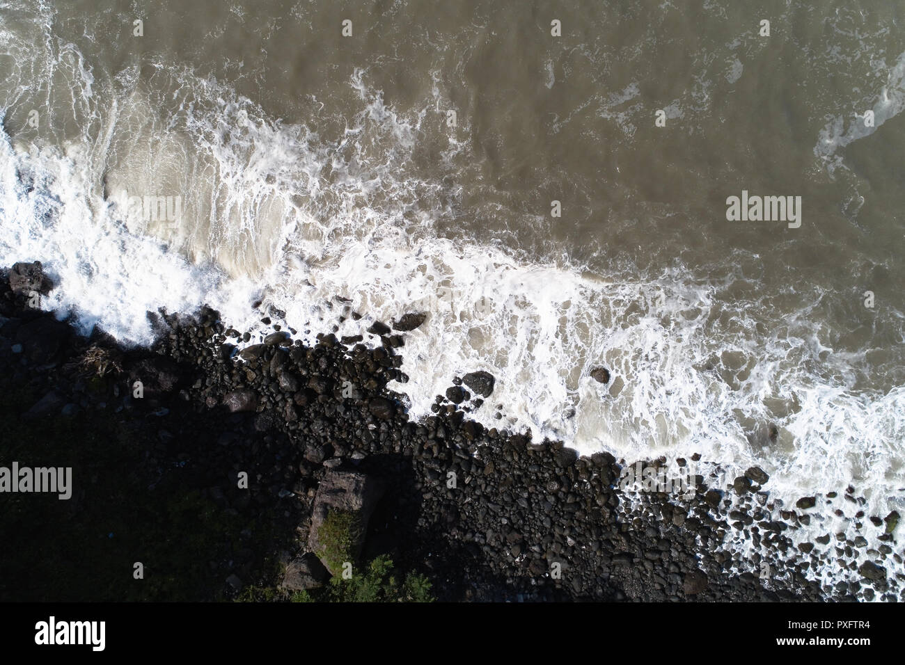 Sea waves and stony shore are photographed from above. Aerial ...