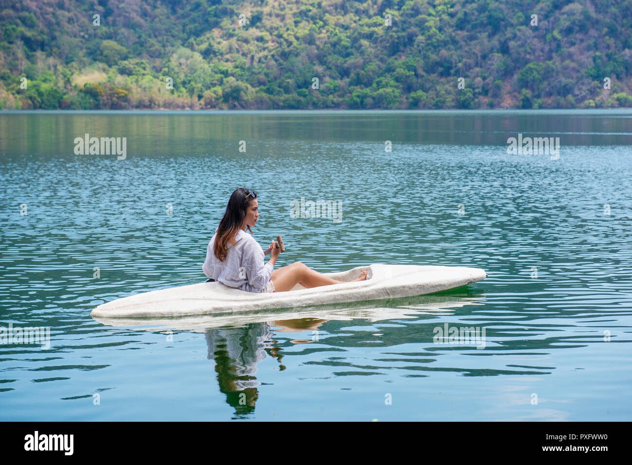 Asian lady paddling the kayak on the lake in satonda island. Sumbawa ...