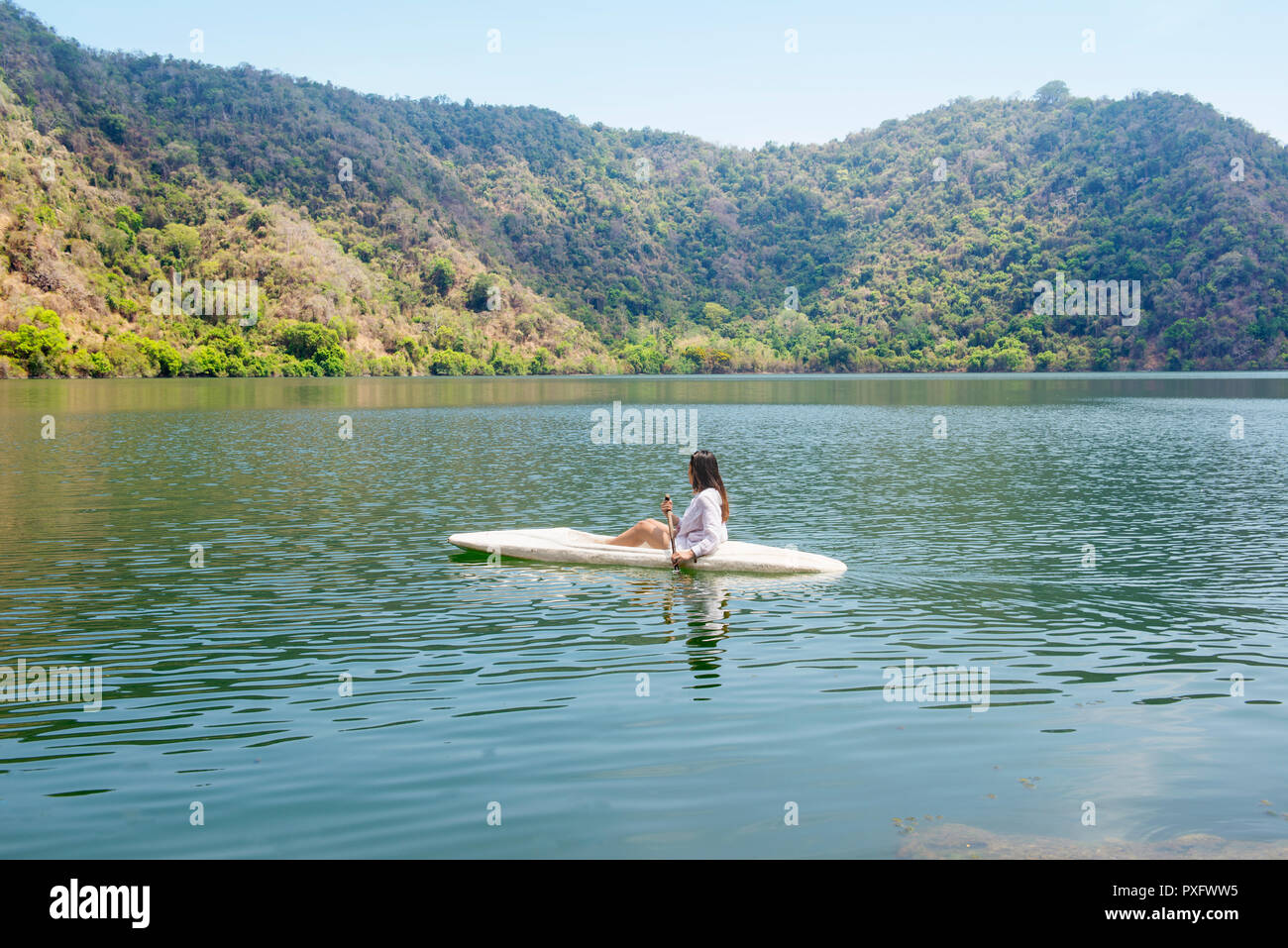 Asian lady paddling the kayak on the lake in satonda island. Sumbawa ...
