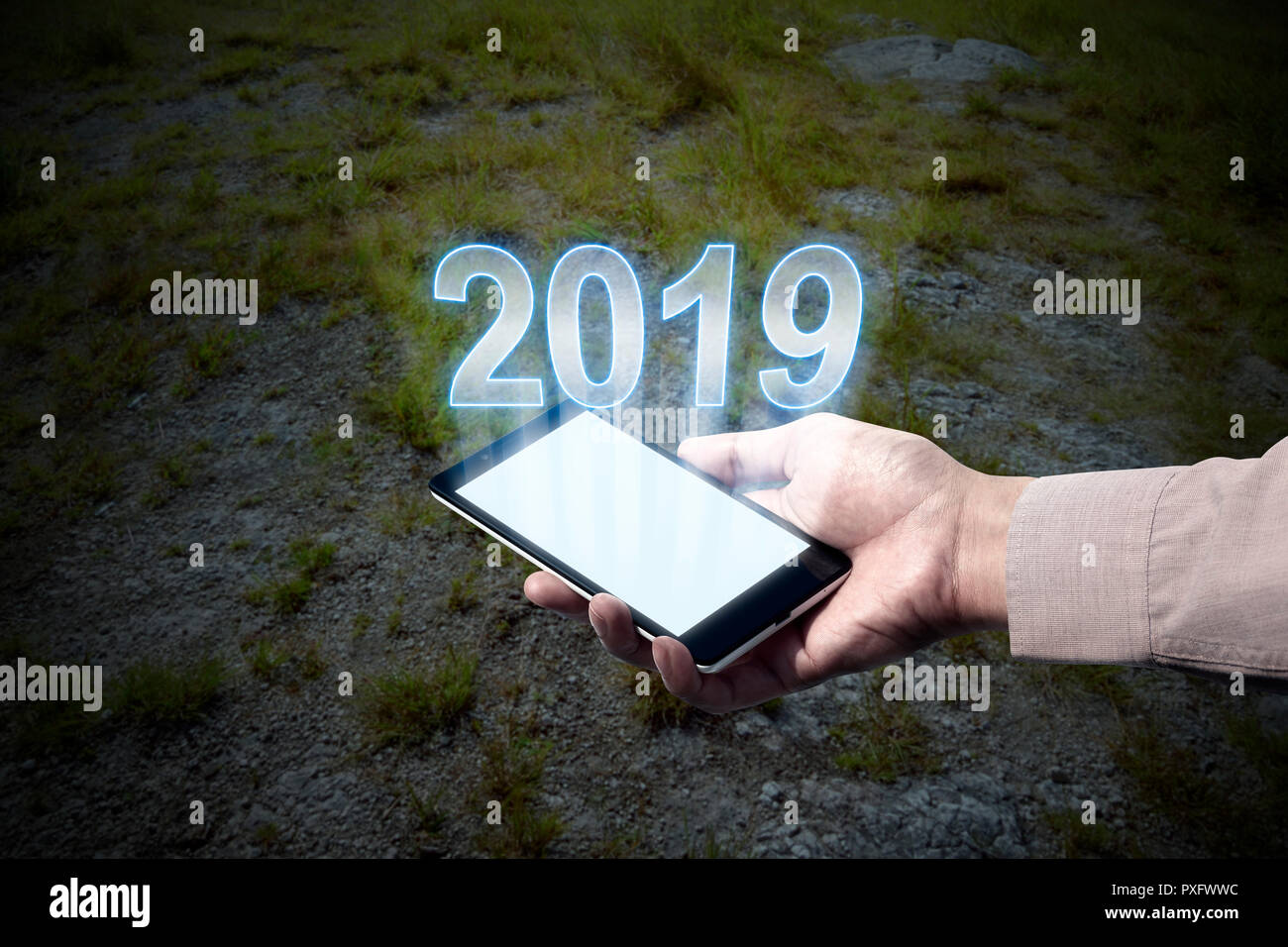 Hand holding phone with 2019 number showing from screen. Happy New Year ...