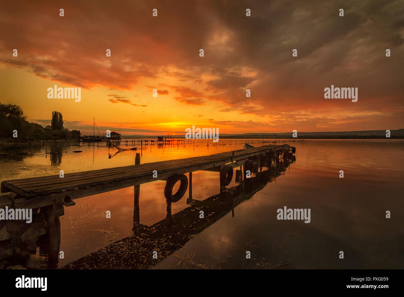 Stunning sunset at the seashore at a port with wooden pier Stock Photo ...