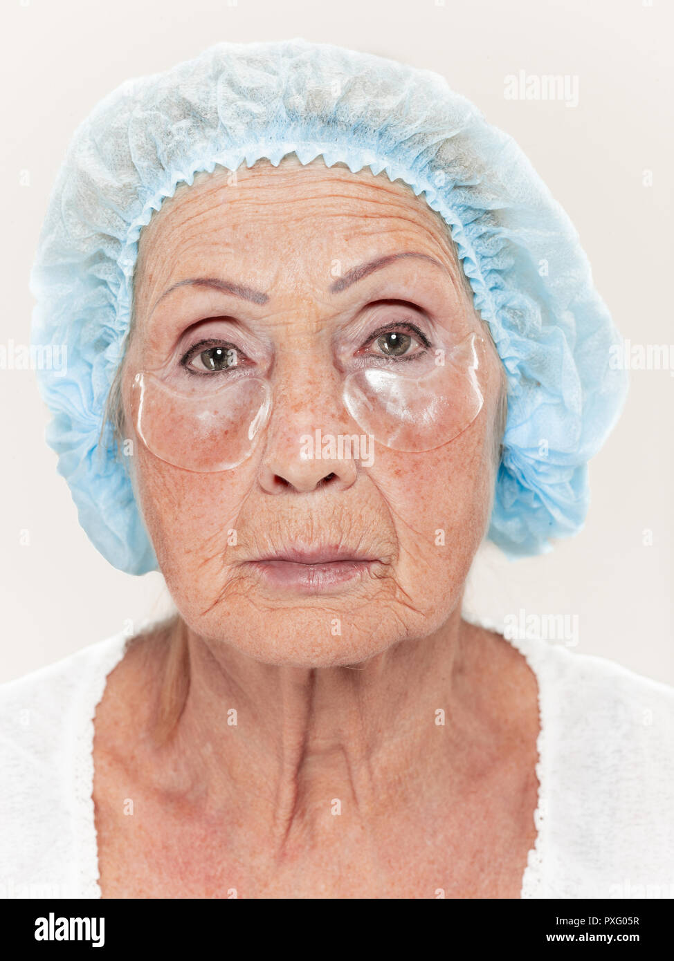 Senior woman studio isolated on white wall beauty concept looking at ...