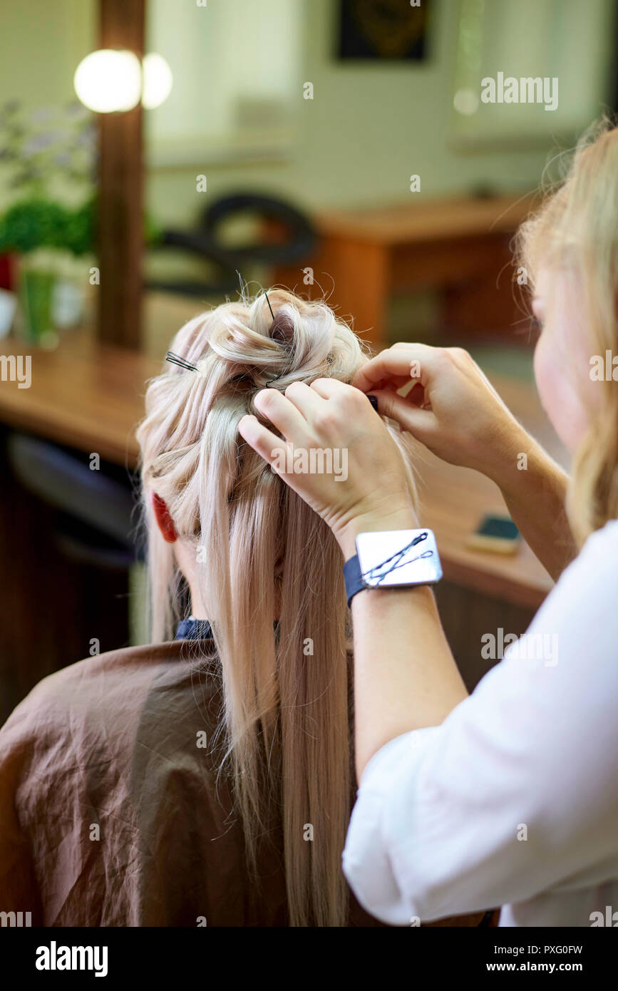 Hairdressing services.Сreating an evening hairstyle. Hair styling ...
