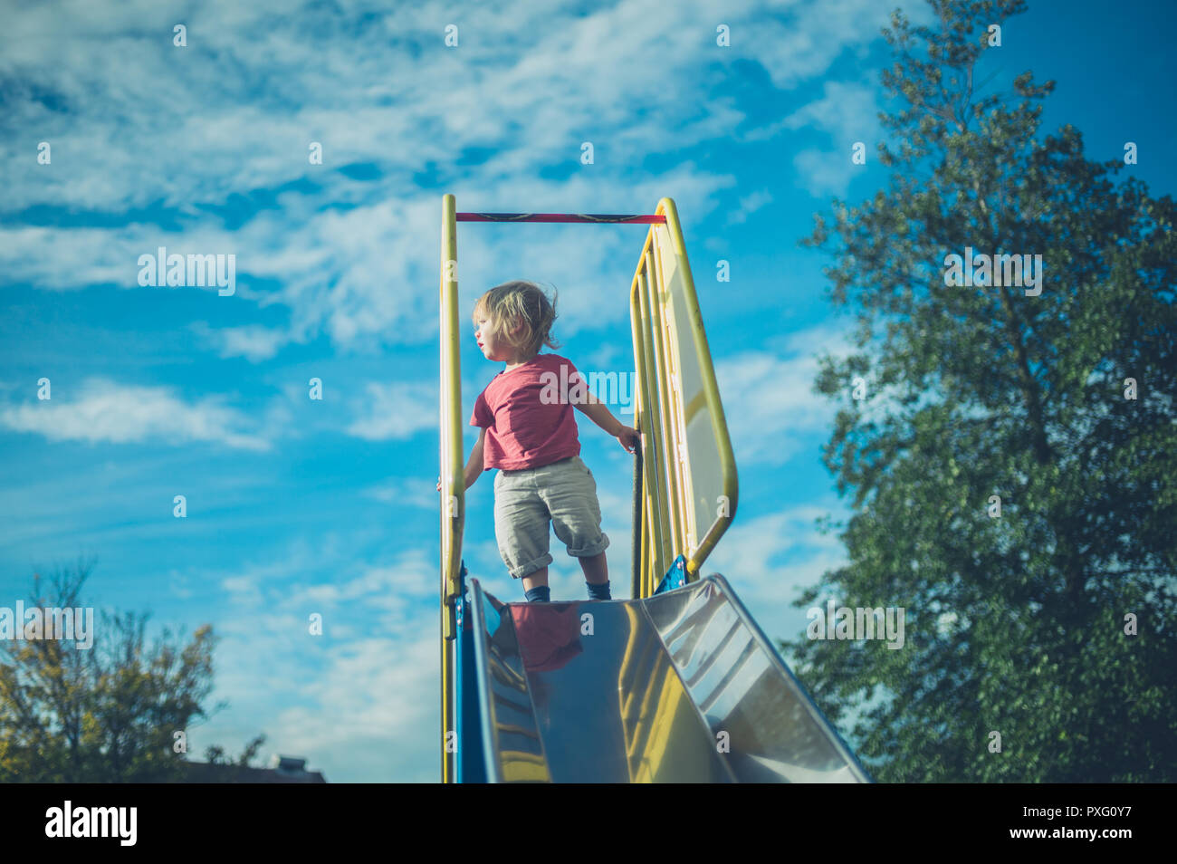 Boy coming down slide hi-res stock photography and images - Alamy
