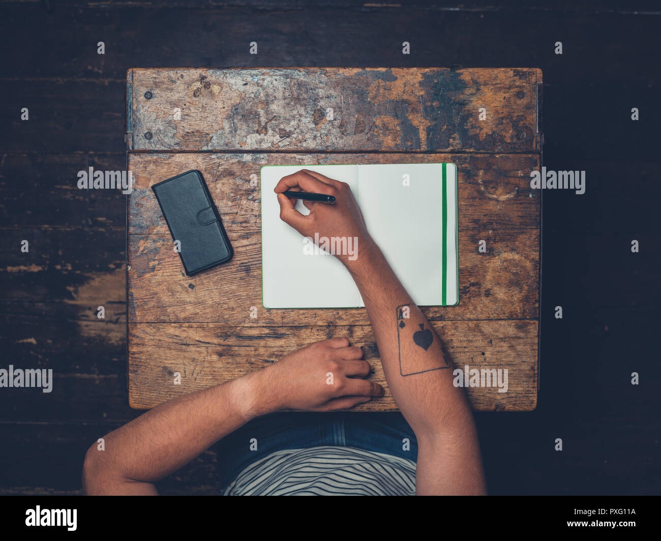 Overhead shot of a man writing in a notebook Stock Photo - Alamy