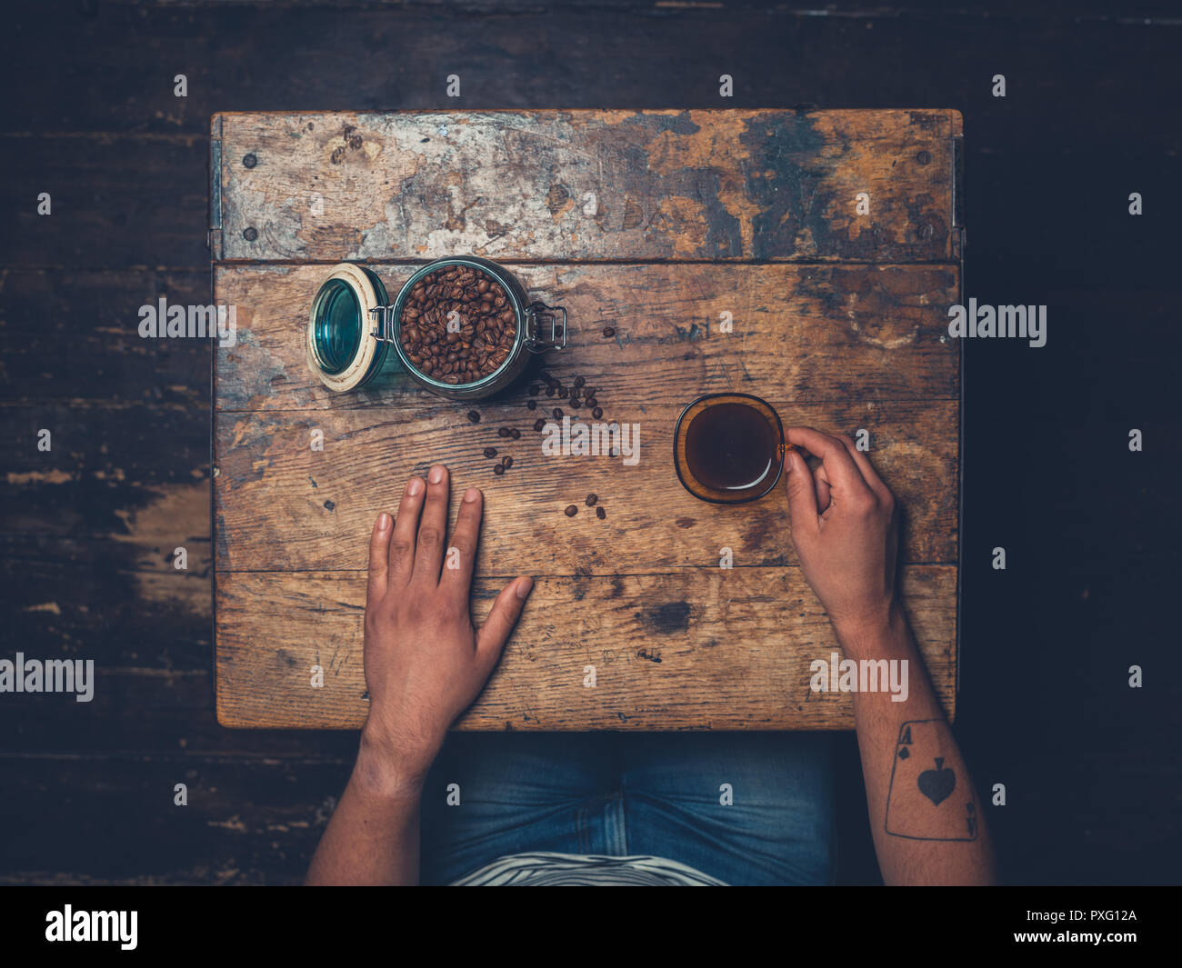 Overhead shot of man with coffee beans drinking coffee Stock Photo - Alamy