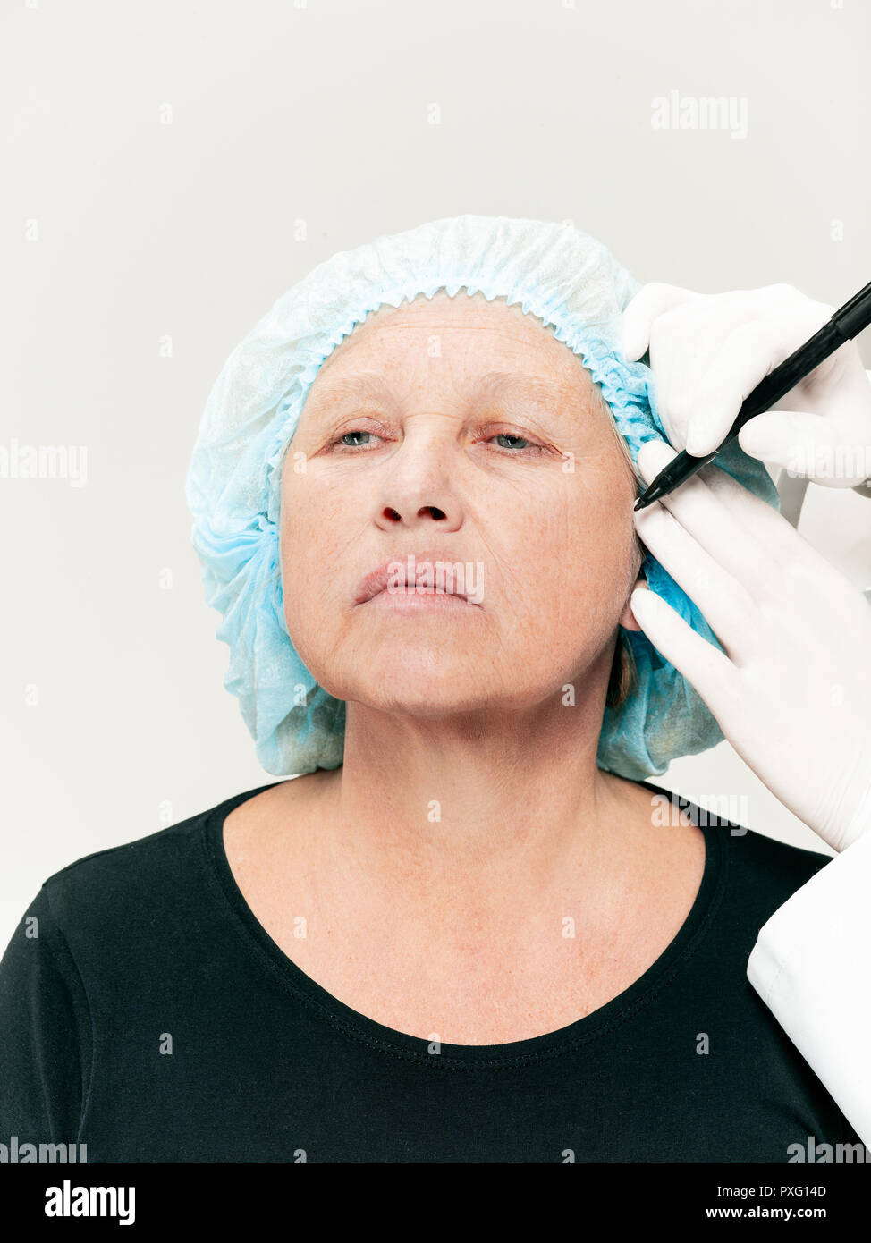 The surgeon doing skin check on mid age woman before plastic surgery ...