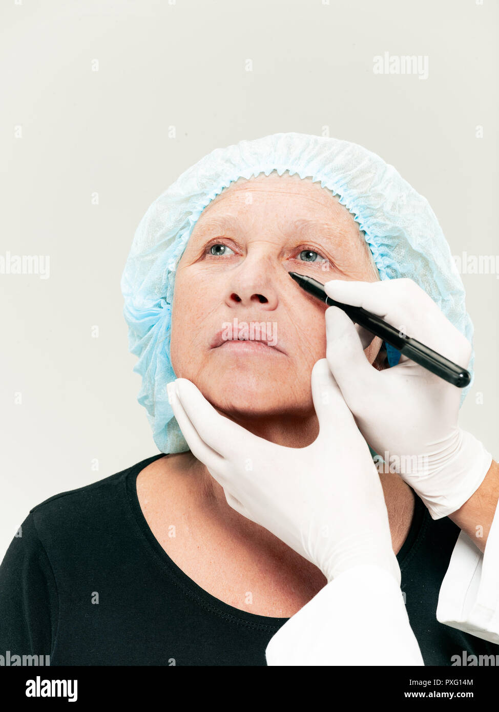 The surgeon doing skin check on mid age woman before plastic surgery ...