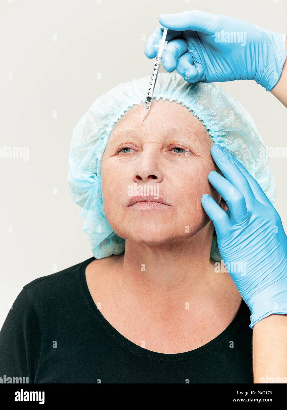 The surgeon doing skin check on mid age woman before plastic surgery ...