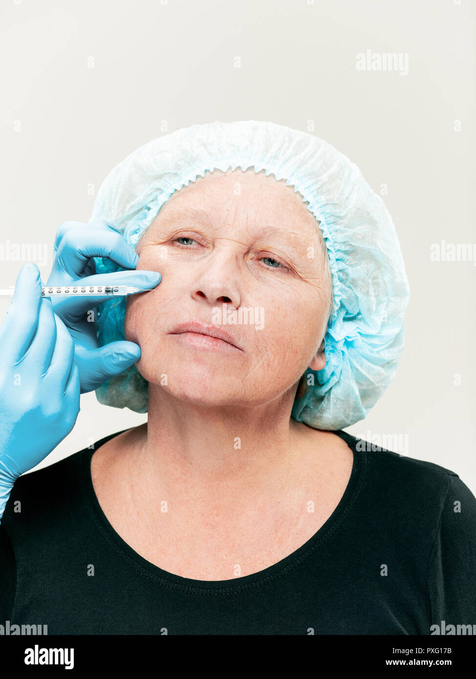 The surgeon doing skin check on mid age woman before plastic surgery ...