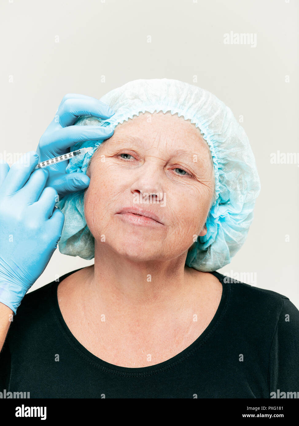 The surgeon doing skin check on mid age woman before plastic surgery ...