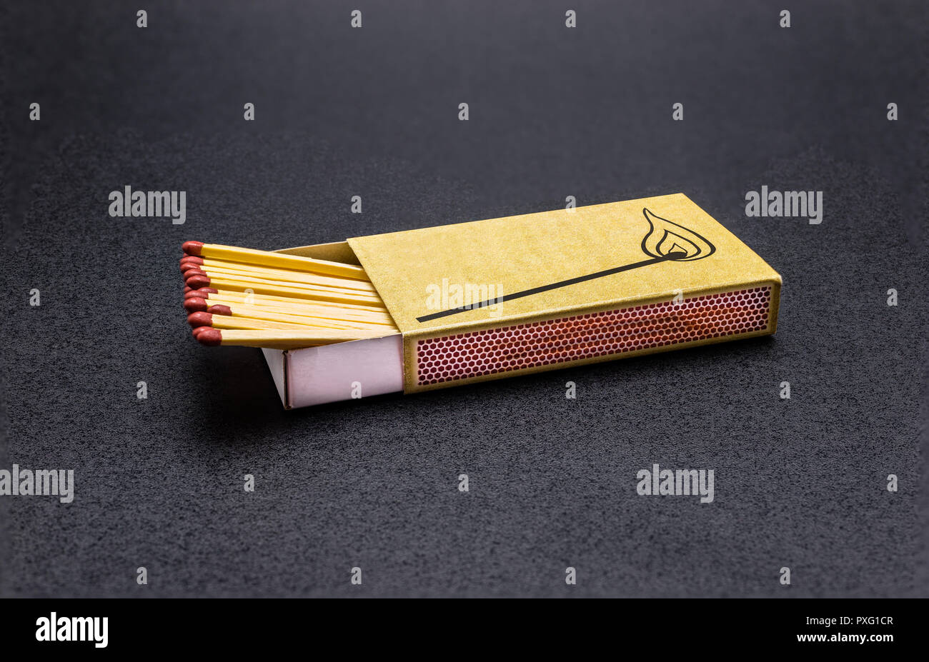 Long matches lying in a matchbox on a black background, with a clipping ...