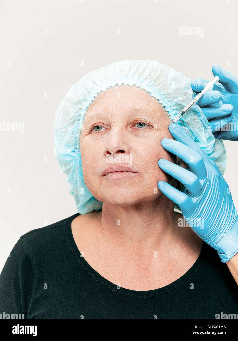 The surgeon doing skin check on mid age woman before plastic surgery ...