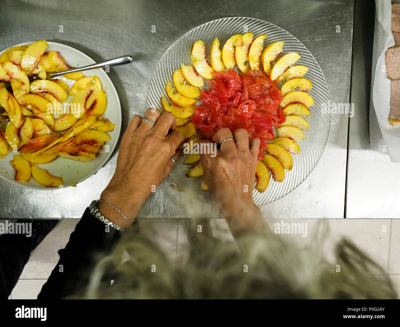 woman Chef preparing a salmon marinated in vodka with fruits and pepper ...